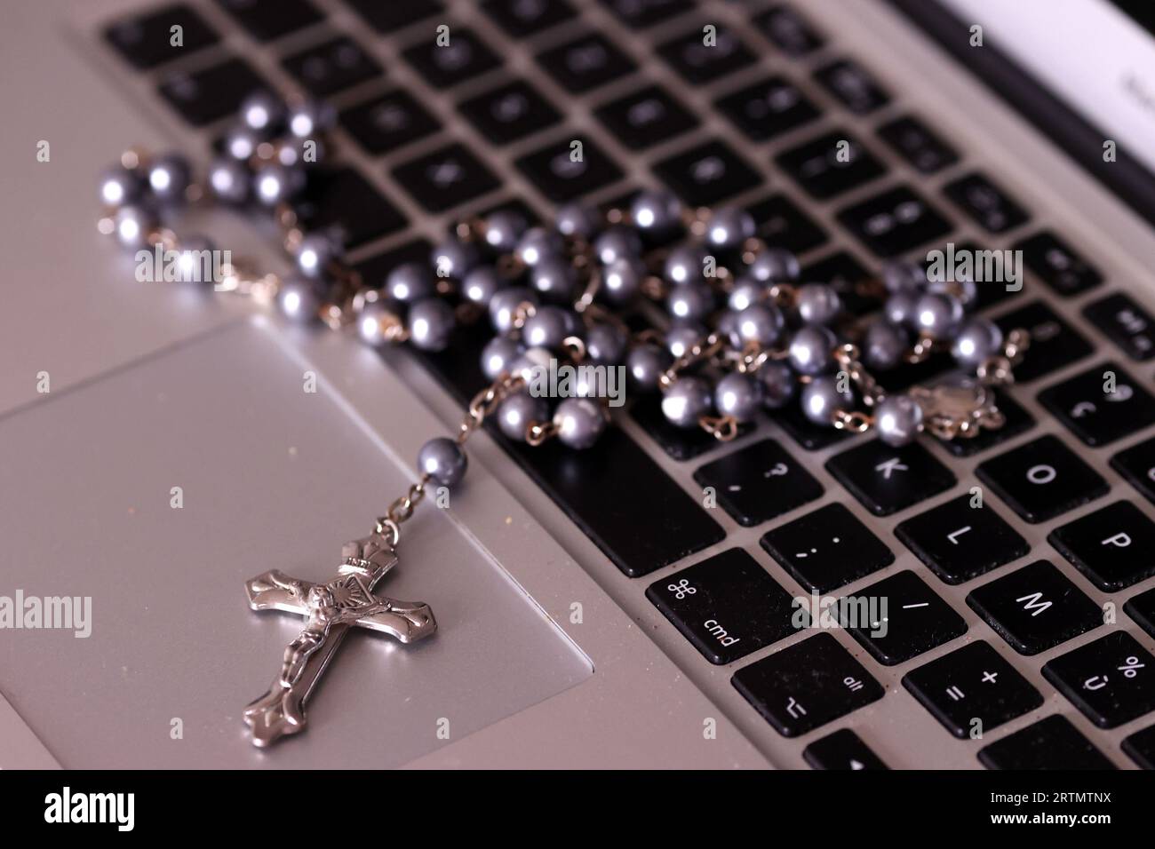 Rosary on a laptop. Religious and digital symbols Stock Photo - Alamy