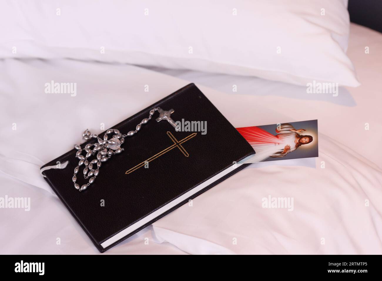 Bible, rosary and picture of Jesus on a bed. Religion at home Stock ...