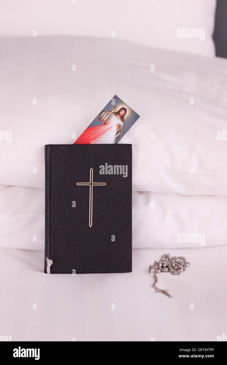 Bible, rosary and picture of Jesus on a bed. Religion at home Stock ...