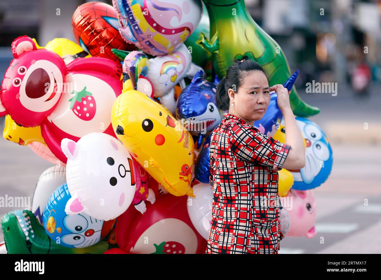 Woman selling air balloon toys at street. Ho Chi Minh city. Vietnam ...