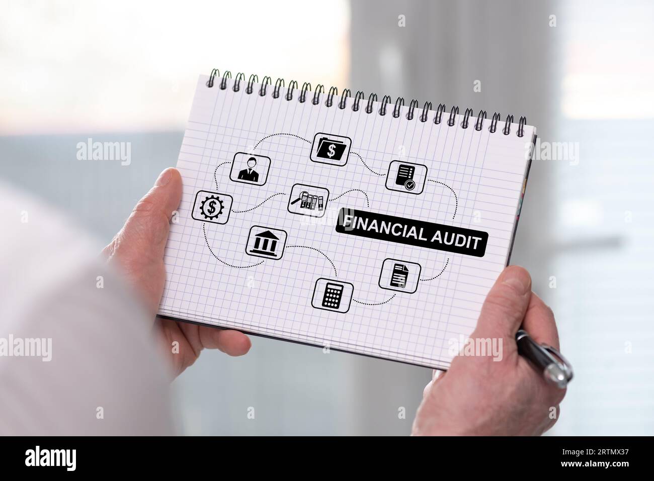 Hand holding a notepad with financial audit concept Stock Photo - Alamy