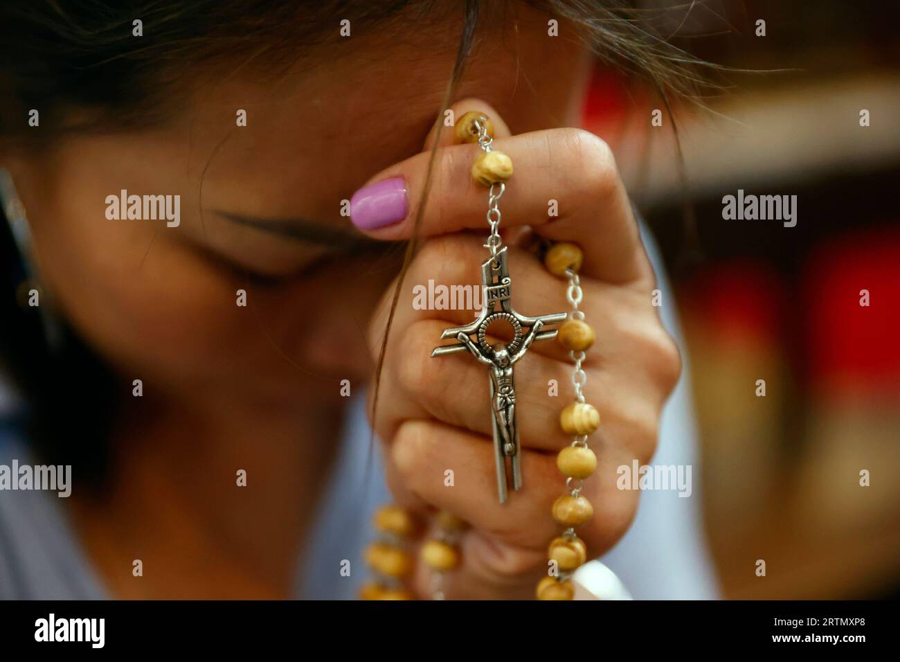 Catholic woman praying with rosary beads in hand. Catholic woman ...