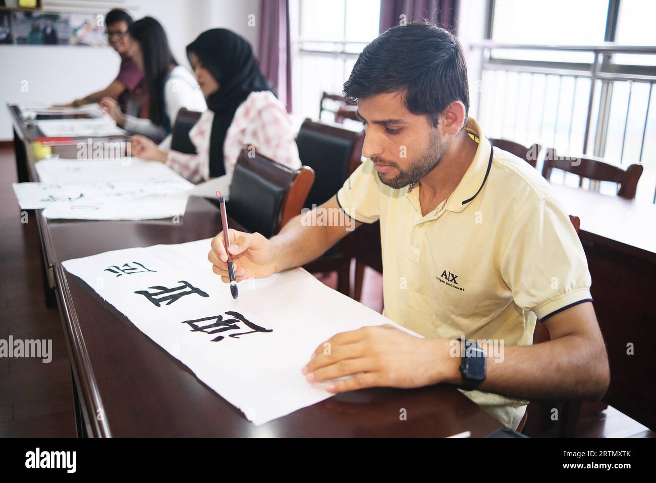 Chinese and foreign students write calligraphy to welcome the 19th ...