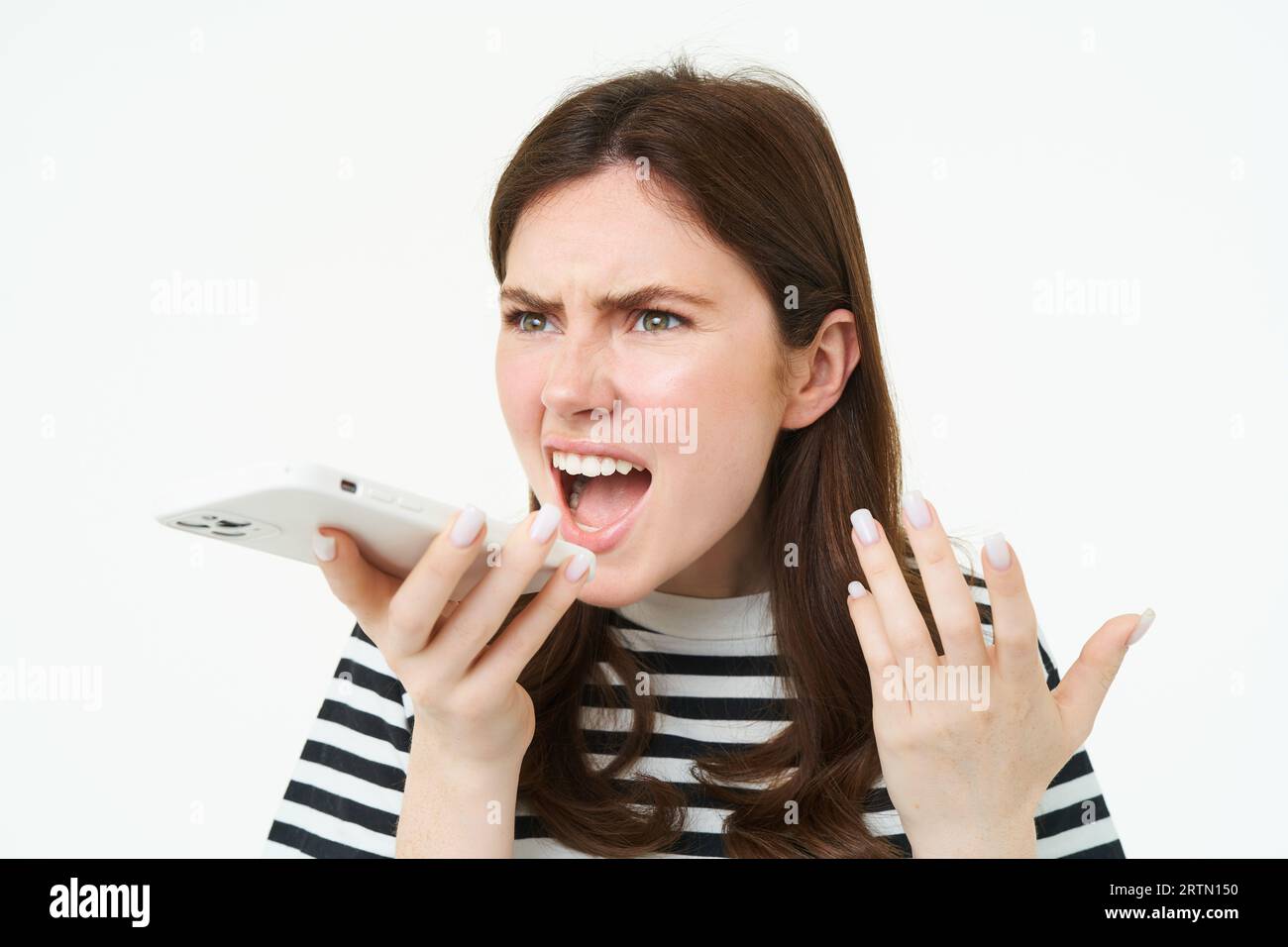 Portrait of angry woman shouting at smartphone speakerphone, recording ...