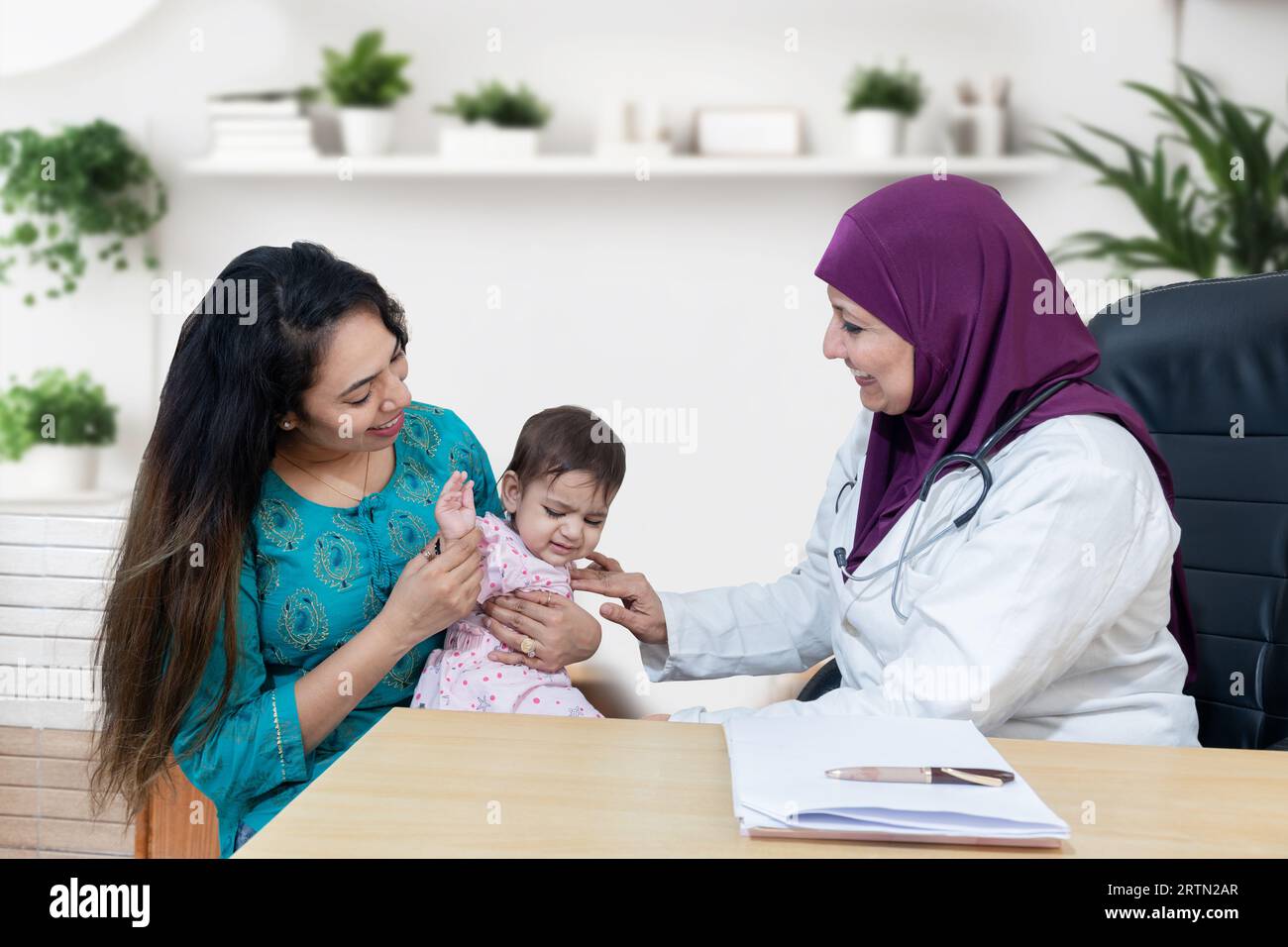 Young indian mother with her cute little baby visiting female muslim ...