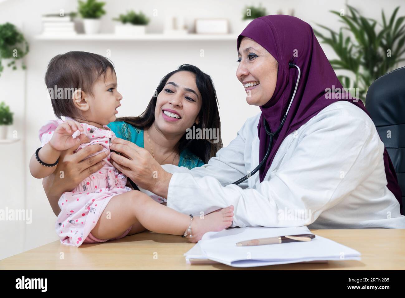 Young indian mother with her cute little baby visiting female muslim ...