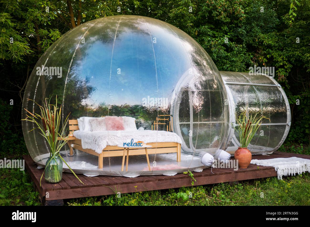 View of a transparent bubble tent at glamping with furniture inside ...