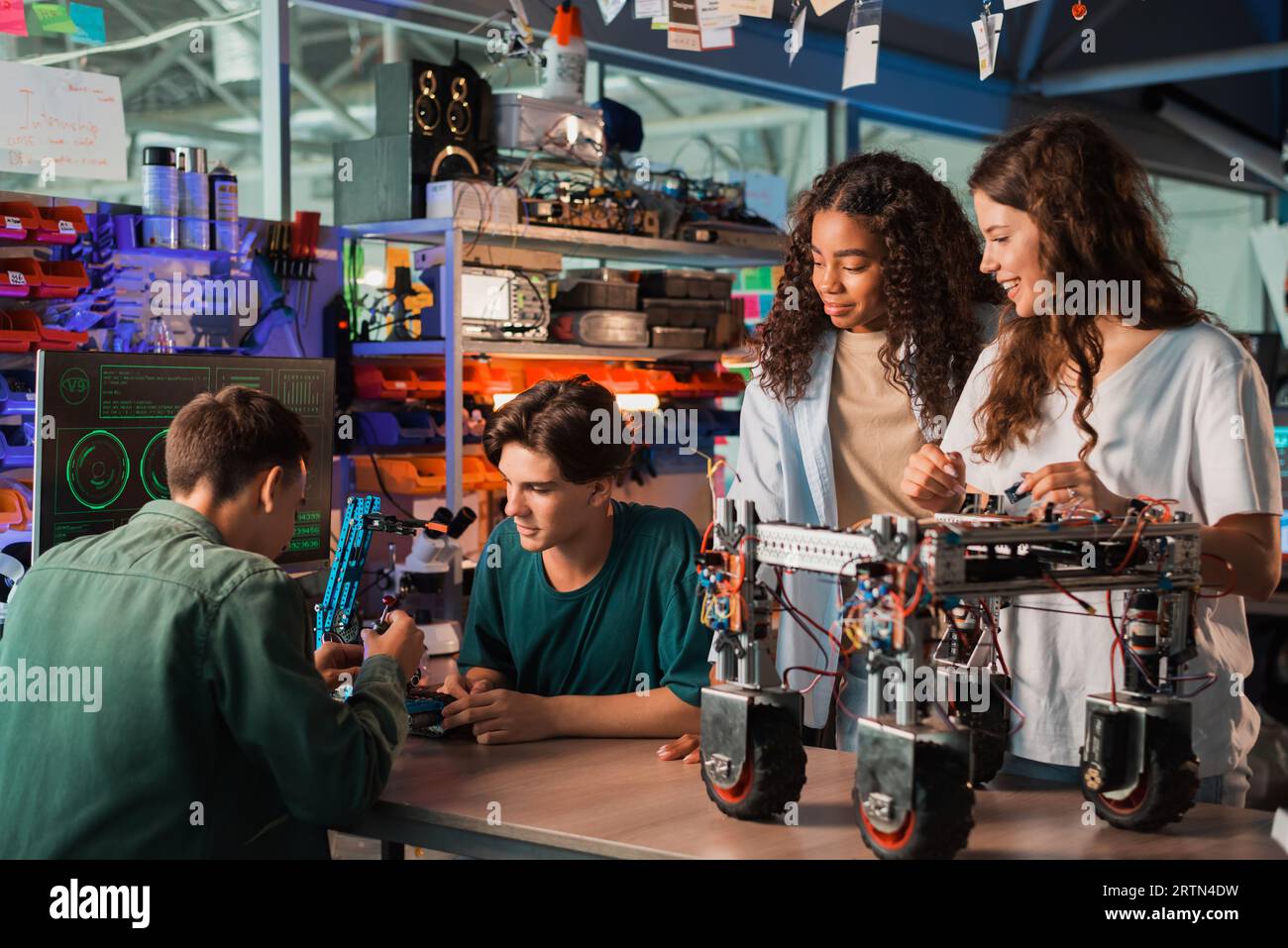 Group of young people doing experiments in robotics in a laboratory ...