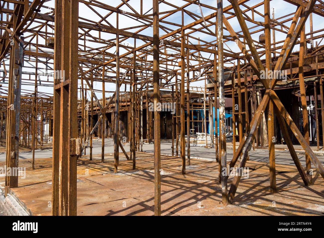 Charred remains of market stalls and metal structures after a fire ...