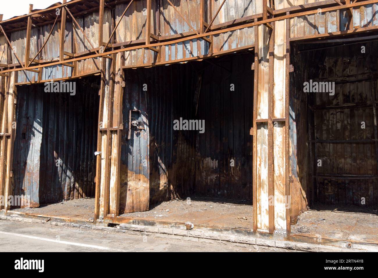 Charred remains of market stalls and metal structures after a fire ...