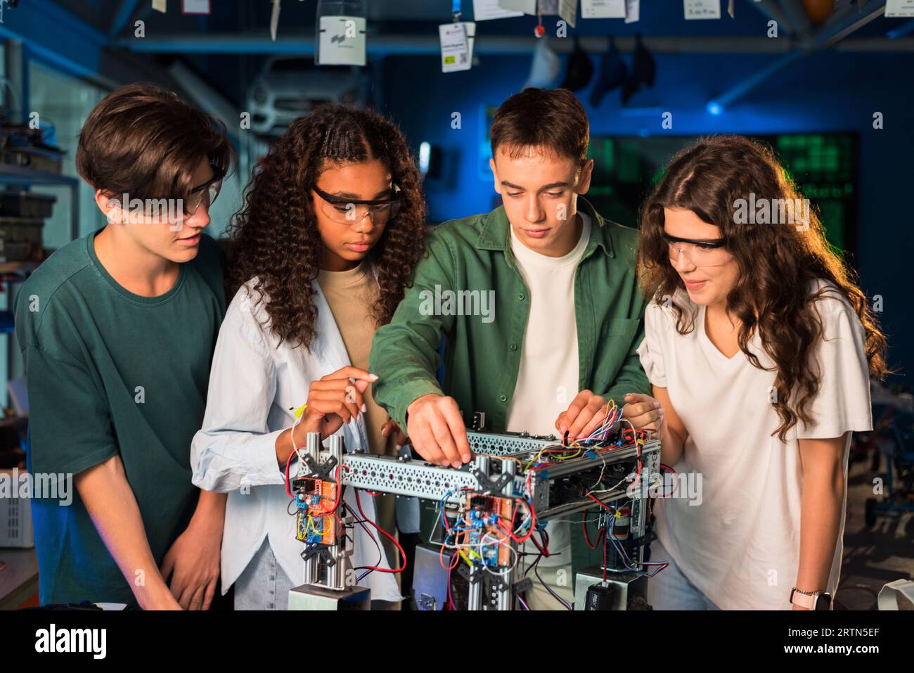 Group of young people doing experiments in robotics in a laboratory ...
