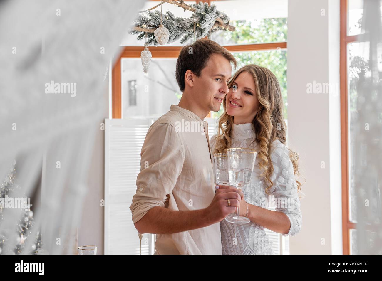Close-up portrait of loving, young fashion couple with glasses of ...