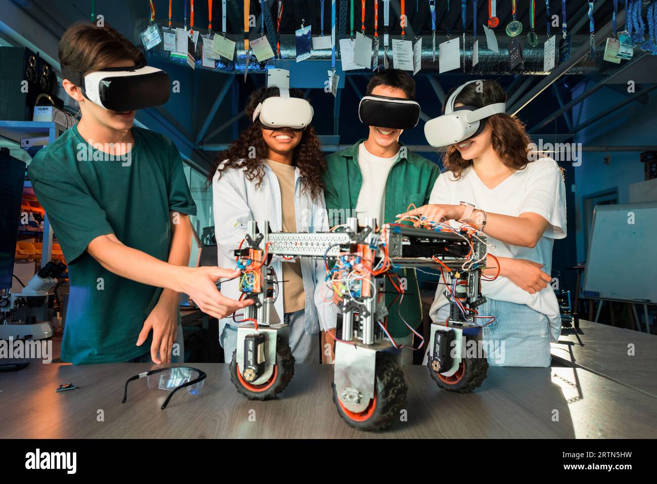 Group of young people in VR glasses doing experiments in robotics in a ...