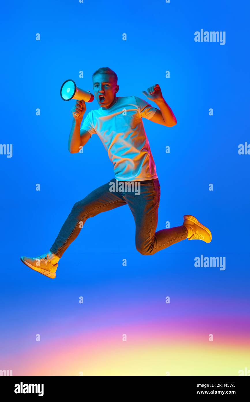 Neon light portrait of victorious delighted, funny jumping man shouting ...