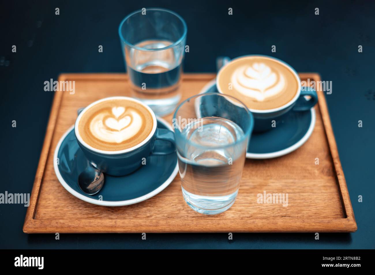 Close view of two cups of coffee with milk with two cups of water Stock ...