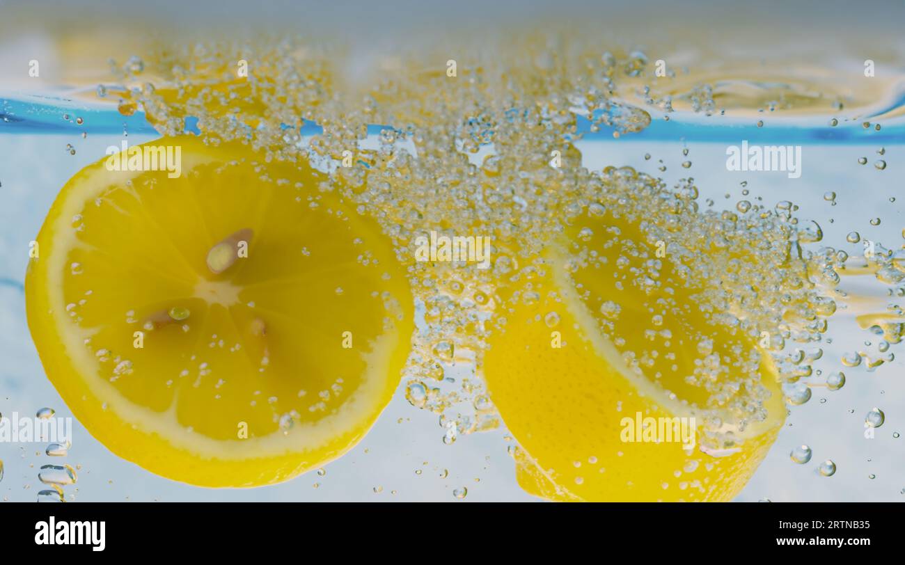 Underwater lemon slice in soda water or lemonade with bubbles. Refreshing soda tonic fizzy ...