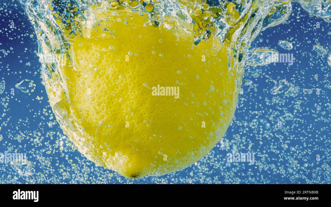 Underwater lemon slice in soda water or lemonade with bubbles. Refreshing soda tonic fizzy ...