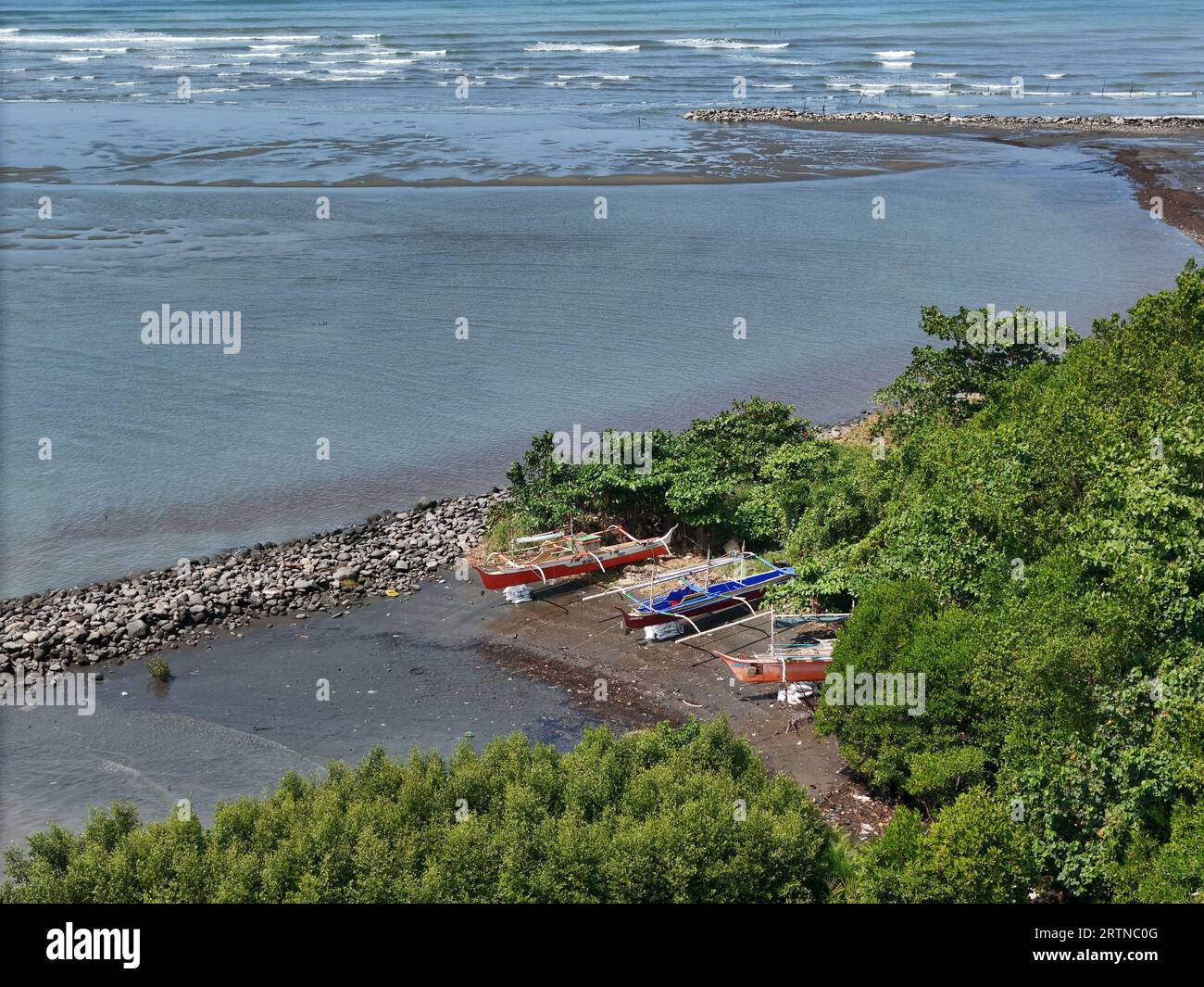An aerial view of several vessels moored on the beachfront in front of ...