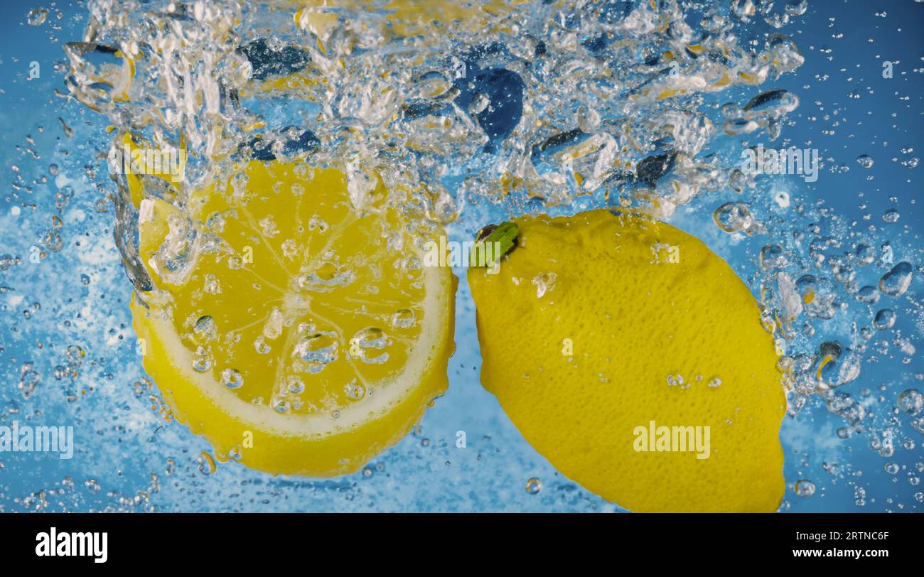 Underwater lemon slice in soda water or lemonade with bubbles. Refreshing soda tonic fizzy ...