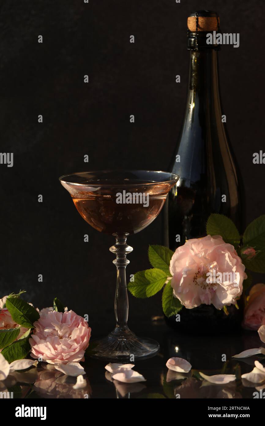 Glass of pink champagne with rose flowers on the black background Stock ...