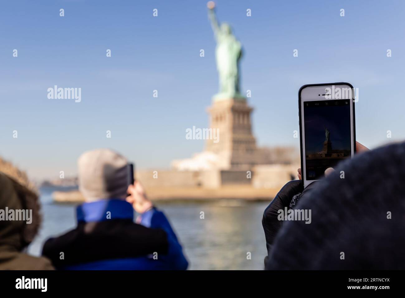 New York City, USA - February 13, 2023 - Tourists taking photos of the Statue of Liberty aboard ...