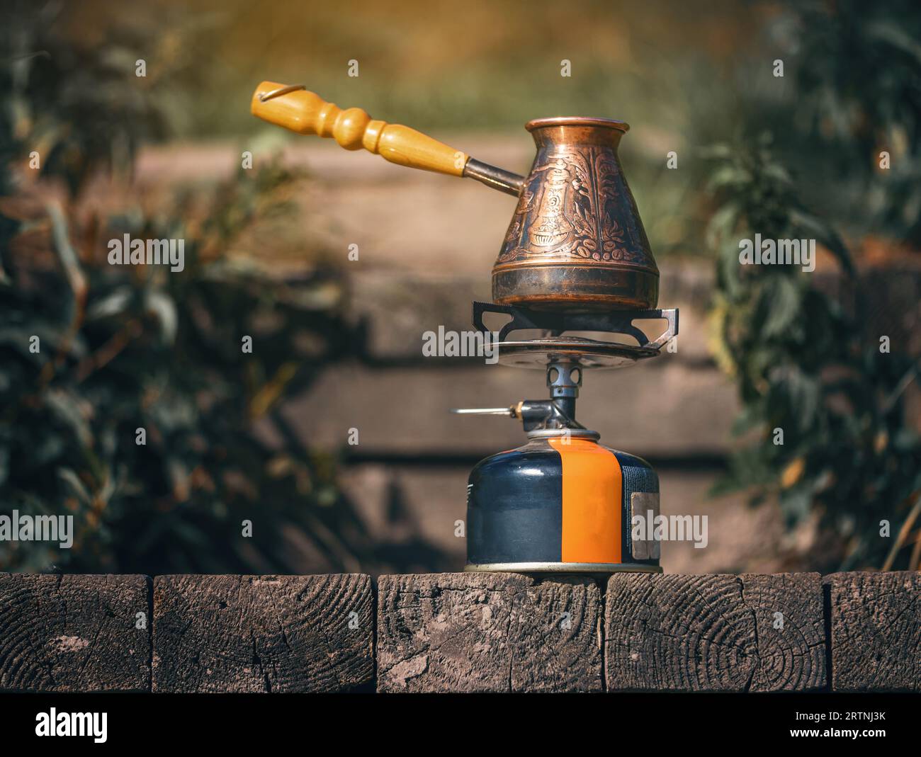 Copper cezve on gas burner in nature. Making coffee in field conditions ...