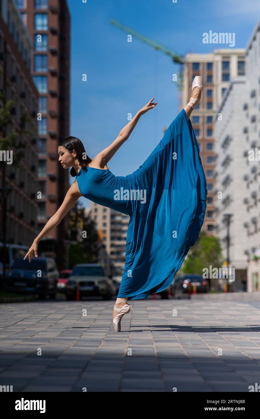 Beautiful Asian ballerina dancing outdoors. Urban landscape Stock Photo ...