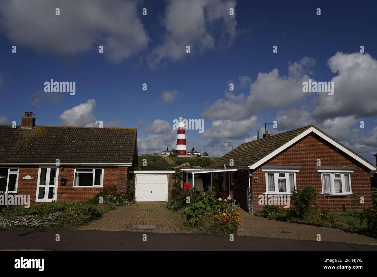 Lighthouse towers over residential housing in Happisburgh Norfolk, UK ...