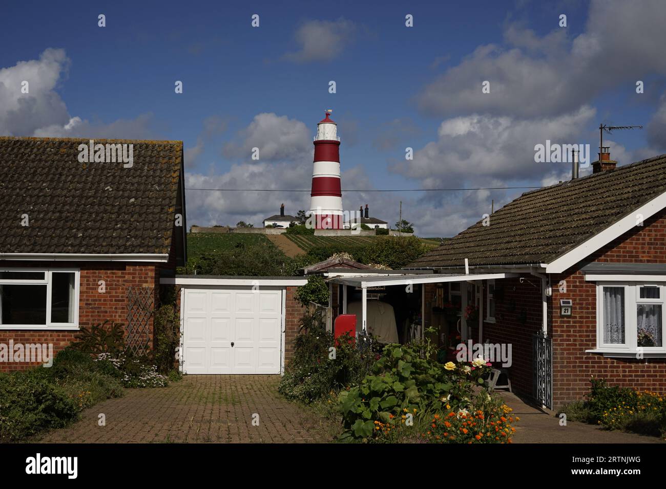 Lighthouse towers over residential housing in Happisburgh Norfolk, UK ...