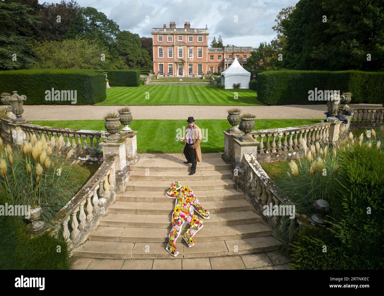 Alexander McDonnell, playing the role of a detective, views a floral ...