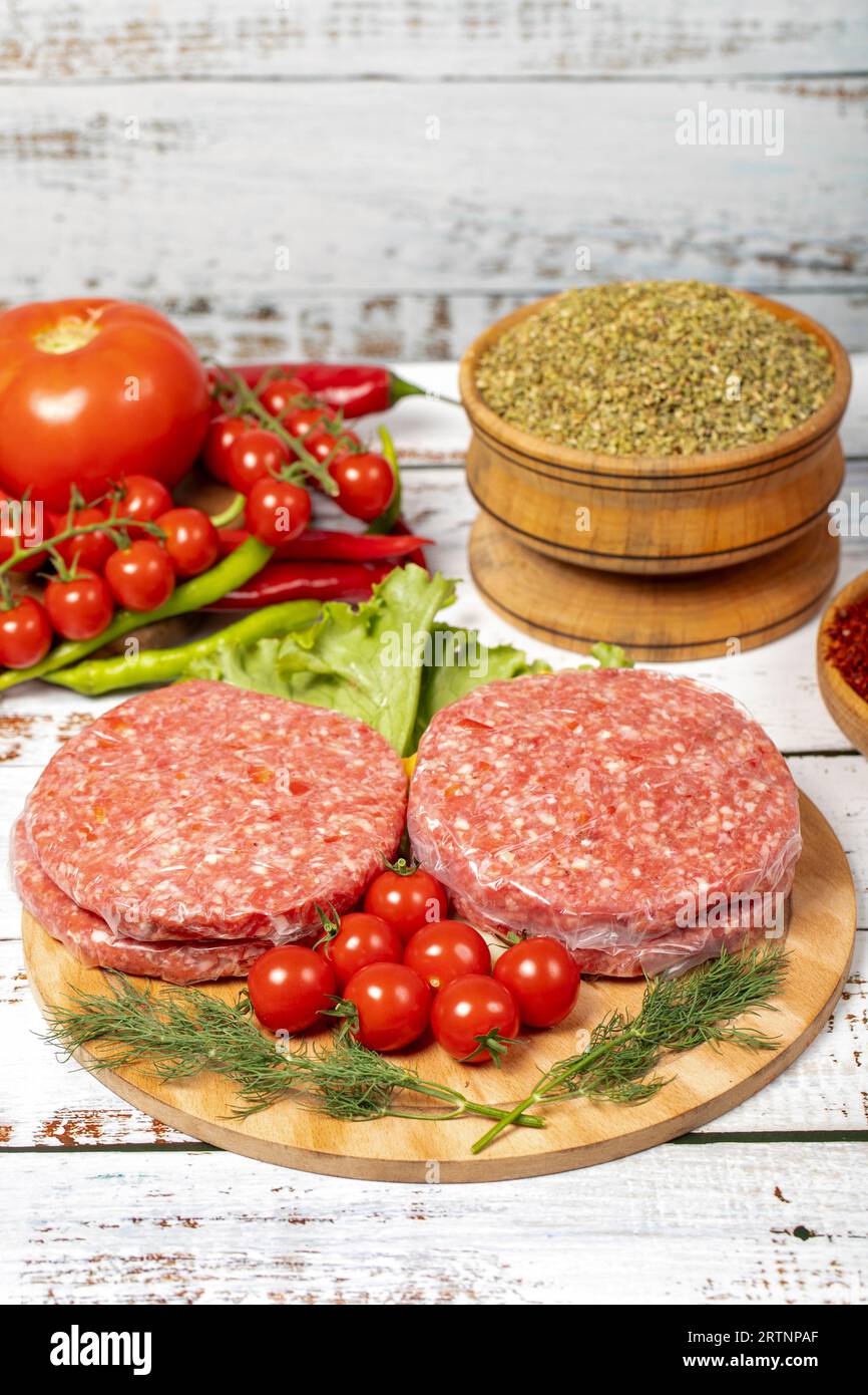 Raw hamburger patties on wood background. Raw veal hamburger patties ...