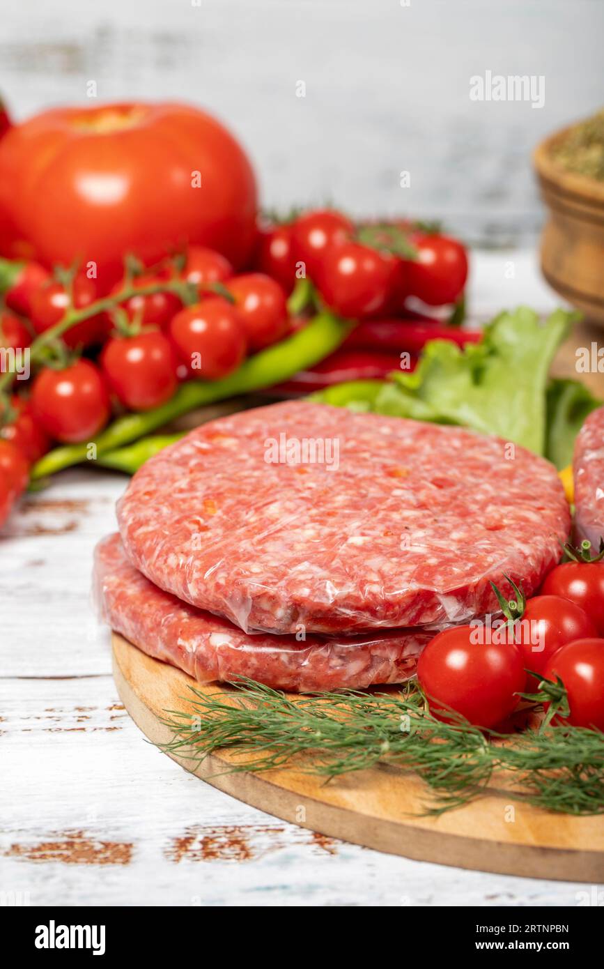 Raw hamburger patties on wood background. Raw veal hamburger patties ...