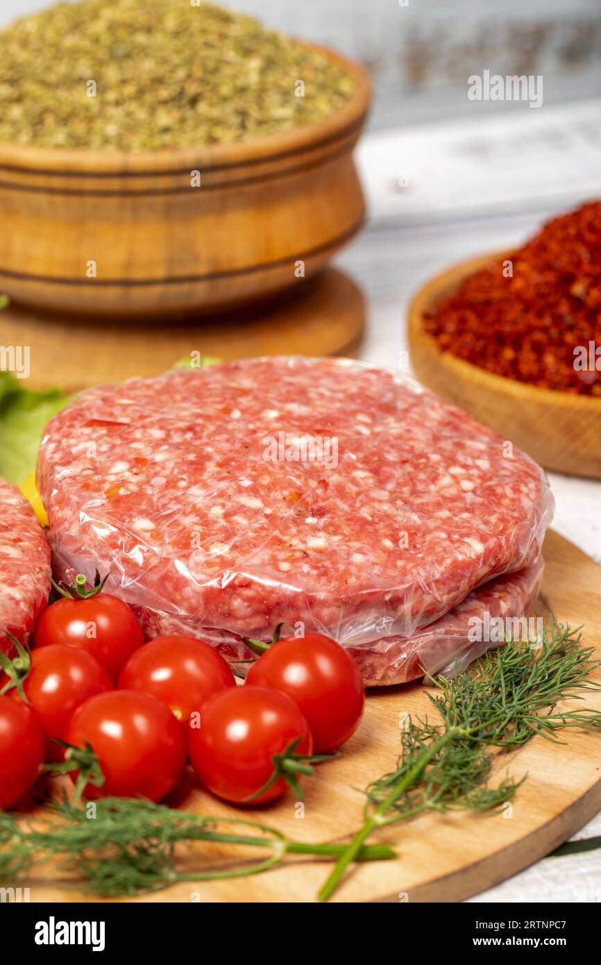 Raw hamburger patties on wood background. Raw veal hamburger patties ...