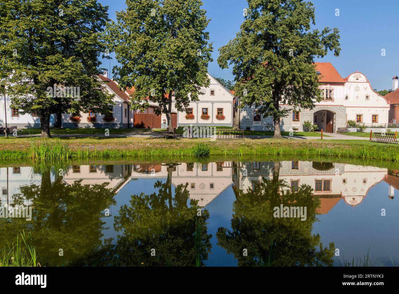 Pond and traditional houses of rural baroque style in Holasovice ...