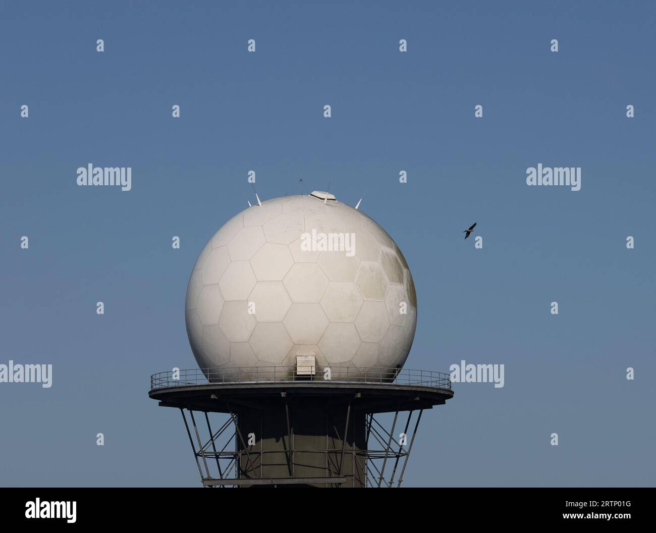 A red kite flying around the national air traffic station radar on ...
