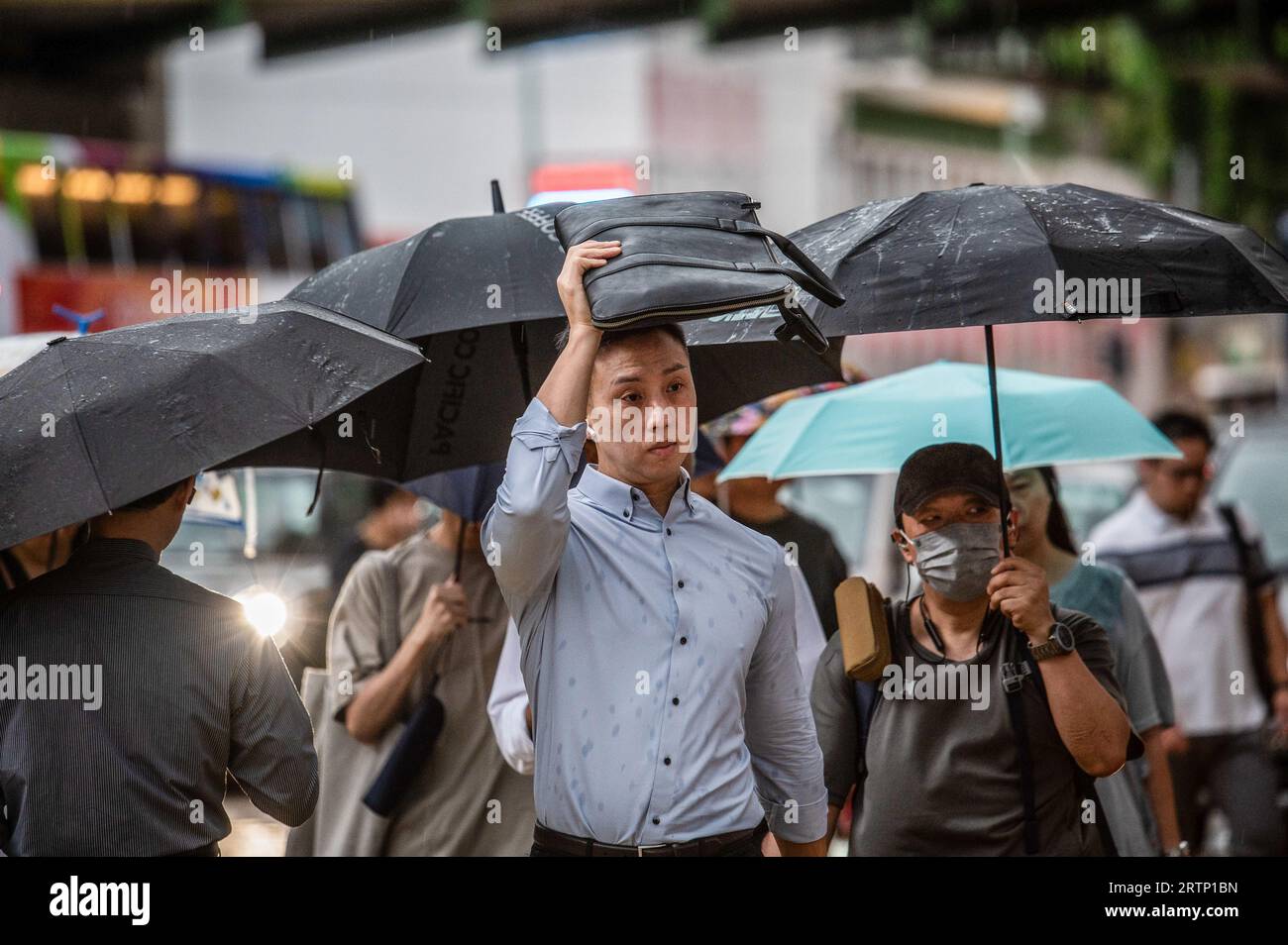 Hong Kong, Hong Kong. 14th Sep, 2023. A man improvises an umbrella in ...