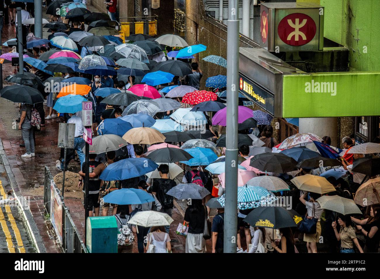 Hong Kong, Hong Kong. 14th Sep, 2023. Commuters take shelter beneath ...