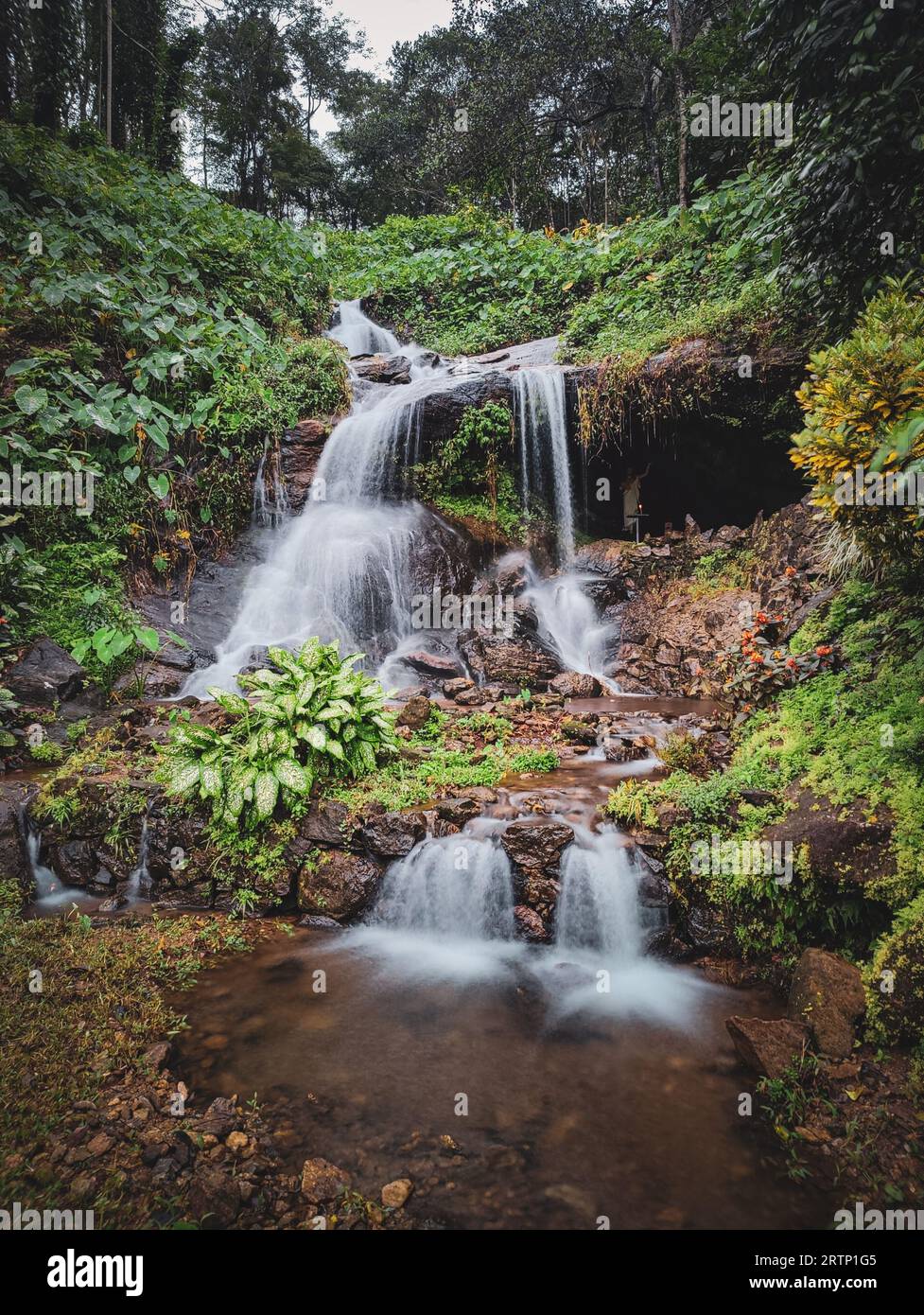 A scenic waterfall cascading over rocks and lush greenery against a ...