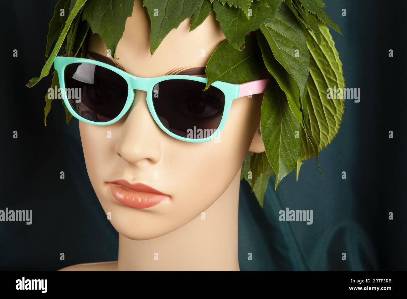 a display mannequin wearing hair of leaves and sunglasses, representing ...
