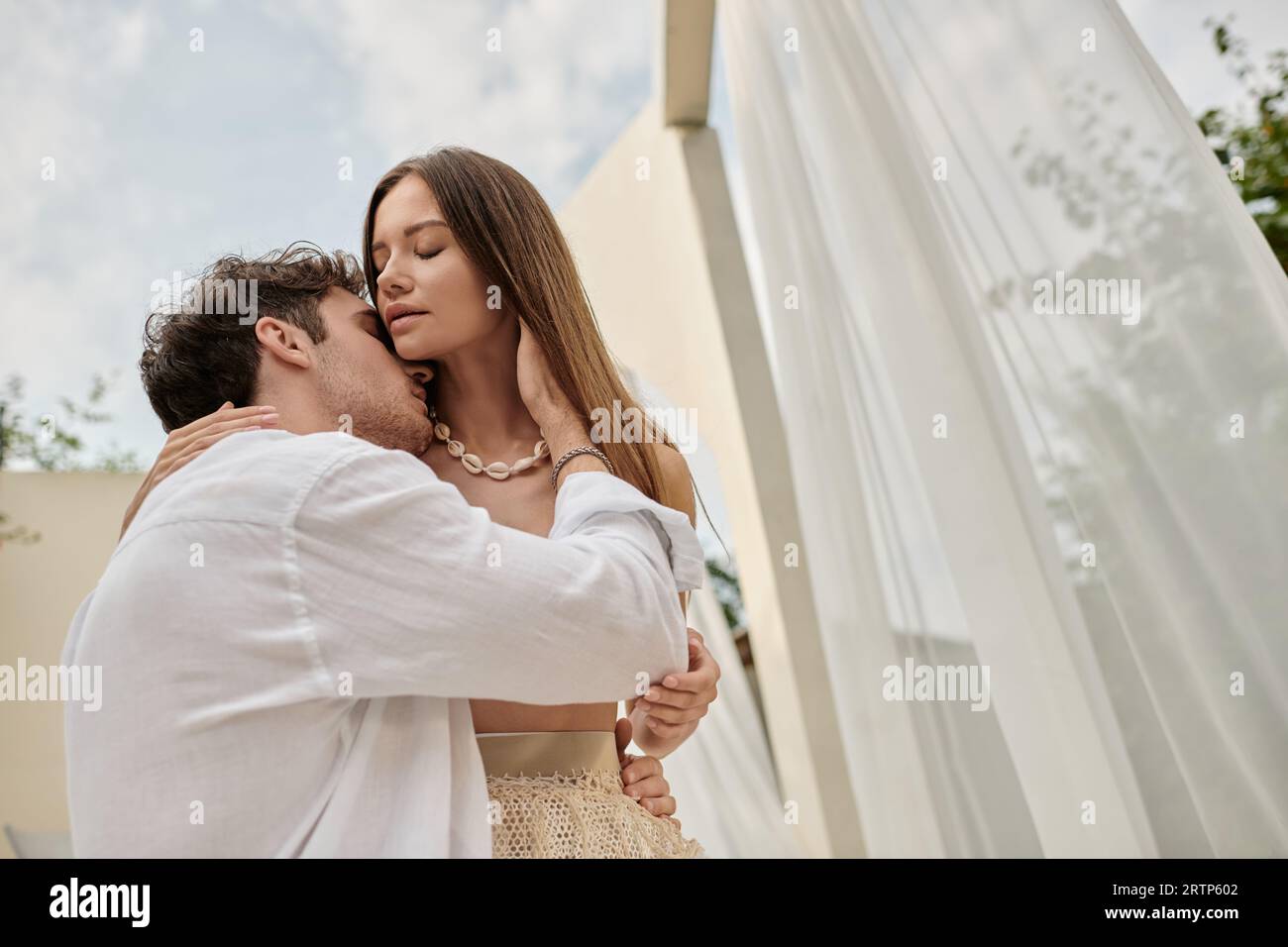 portrait of man embracing attractive woman during romantic getaway in summer, loving gesture ...