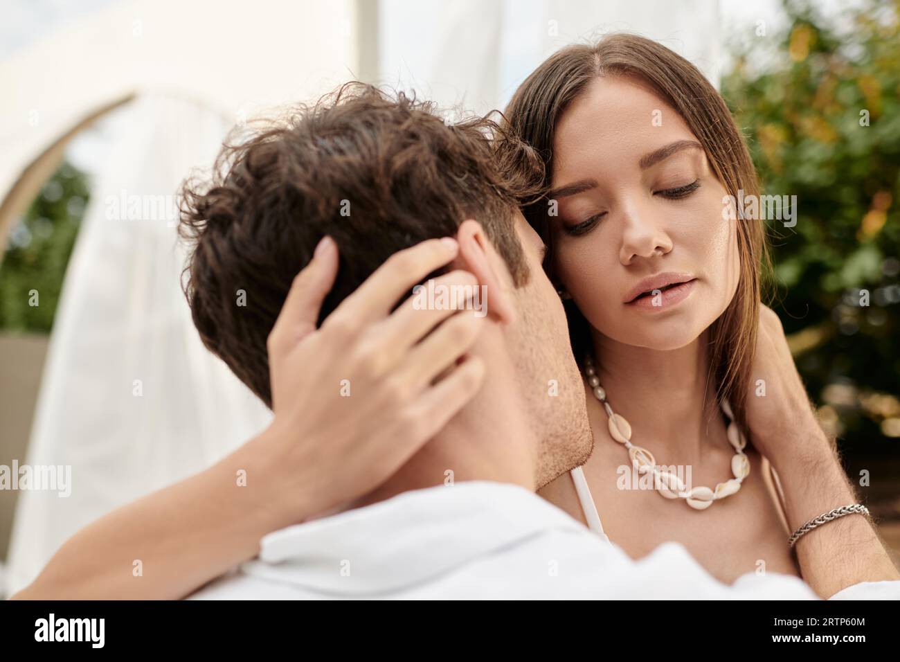 portrait of man embracing beautiful woman during romantic getaway in summer, loving gesture ...