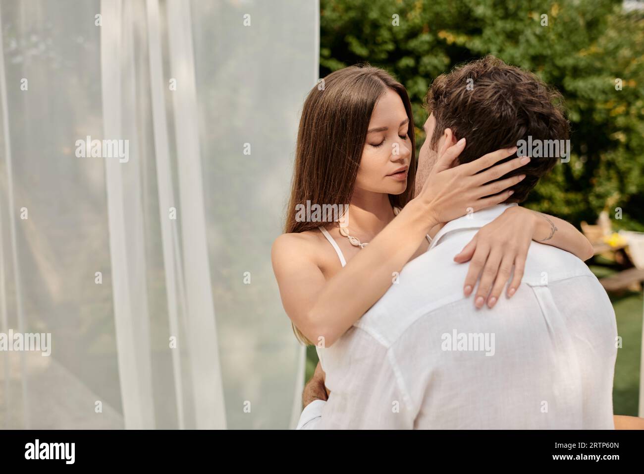 tattooed woman with closed eyes hugging passionate man during summer vacation, romantic getaway ...