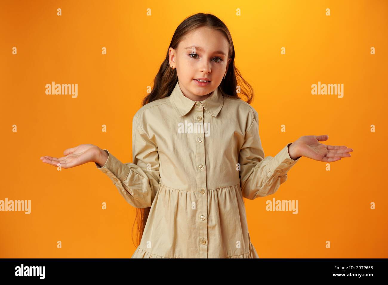 Teen girl shows I don't know gesture against yellow background Stock ...