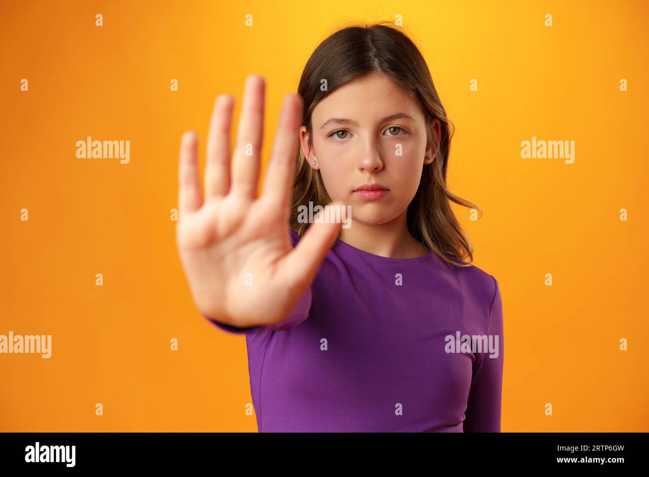 Teen girl extend hand in block gesture against yellow background Stock ...