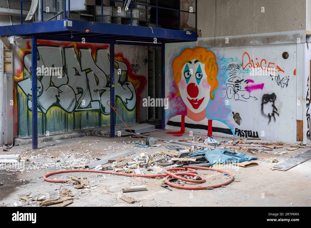 Abandoned factory with graffitis on the wall and debris on the floor in ...