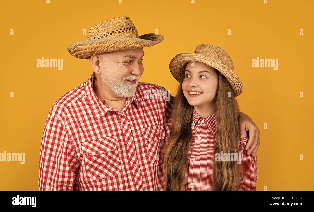 glad child with grandfather in straw hat on yellow background Stock ...