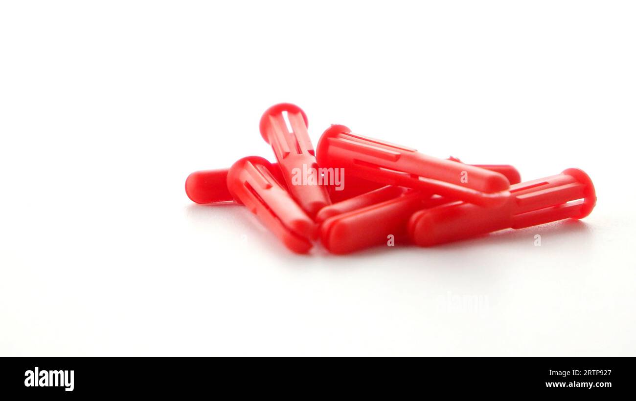 Red plastic dowels isolated on white background Stock Photo - Alamy