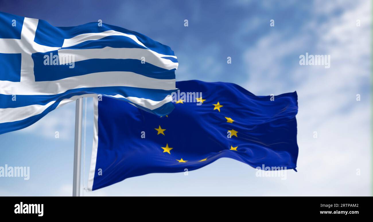 The flags of Greece and the European Union waving together on a clear ...