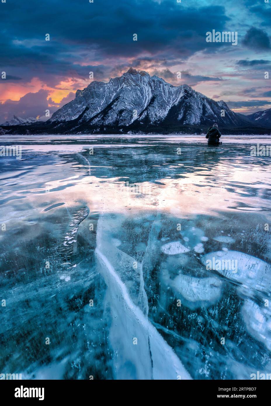 Beautiful sunrise over rocky mountains and frozen lake with methane ...
