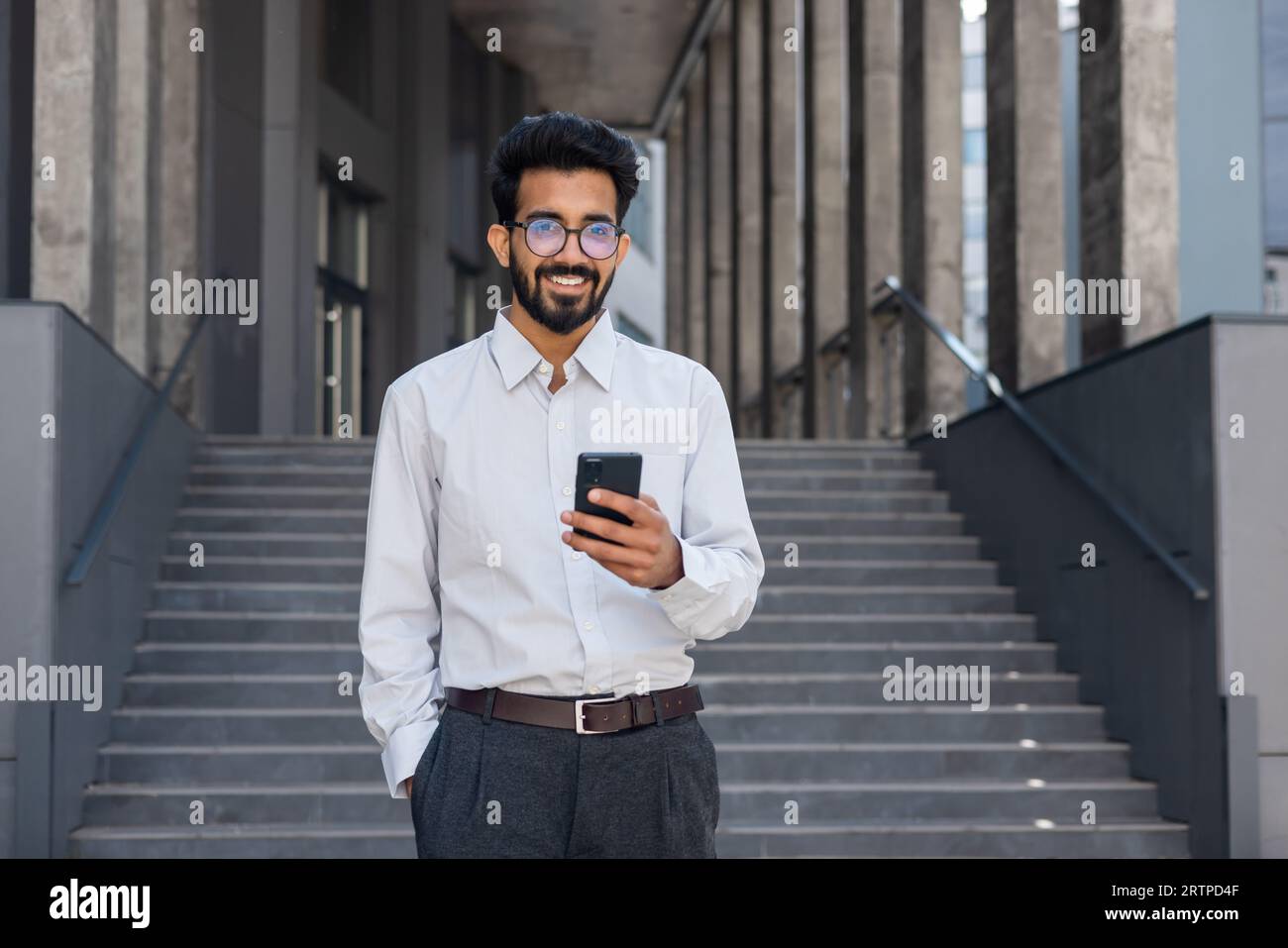 Successful young Hindu man walking outside office building, engineer ...
